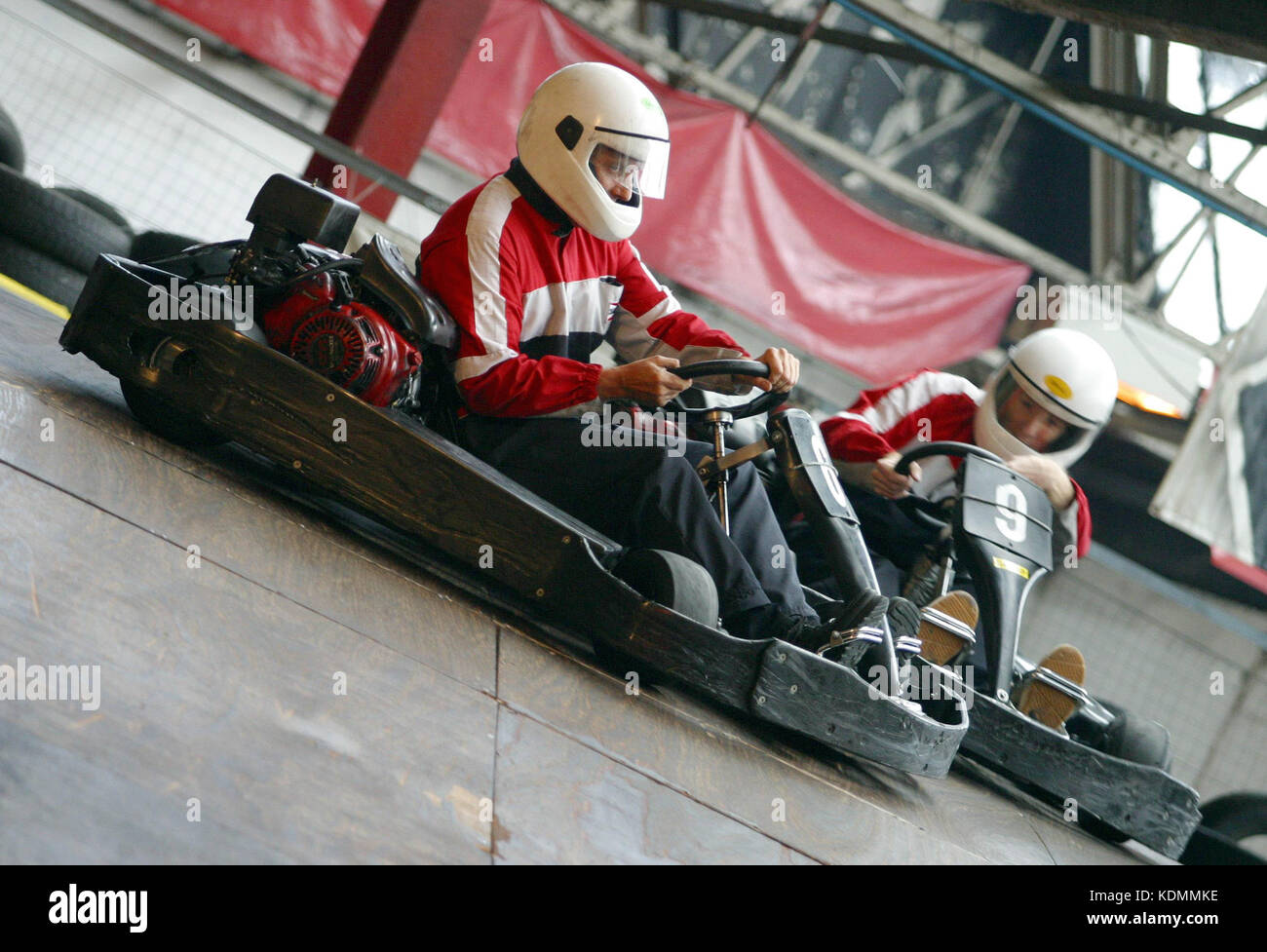 Two men racing in Go Karts at an indoor race arena Stock Photo - Alamy
