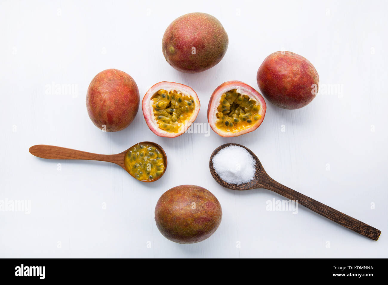 Passion fruit with salt in wooden spoon on wooden white background ...