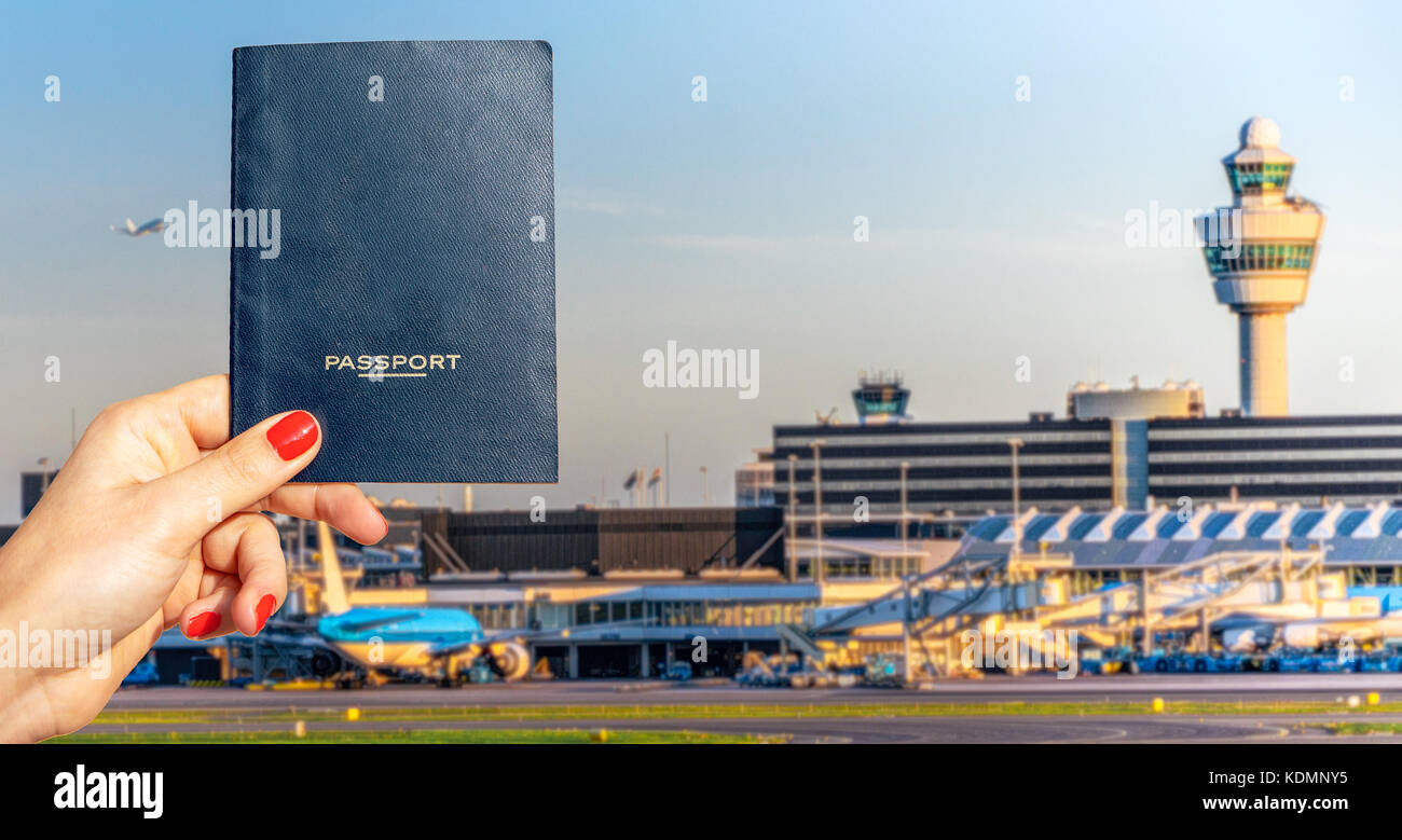 Digital composite of hand holding a generic passport with busy airport ...