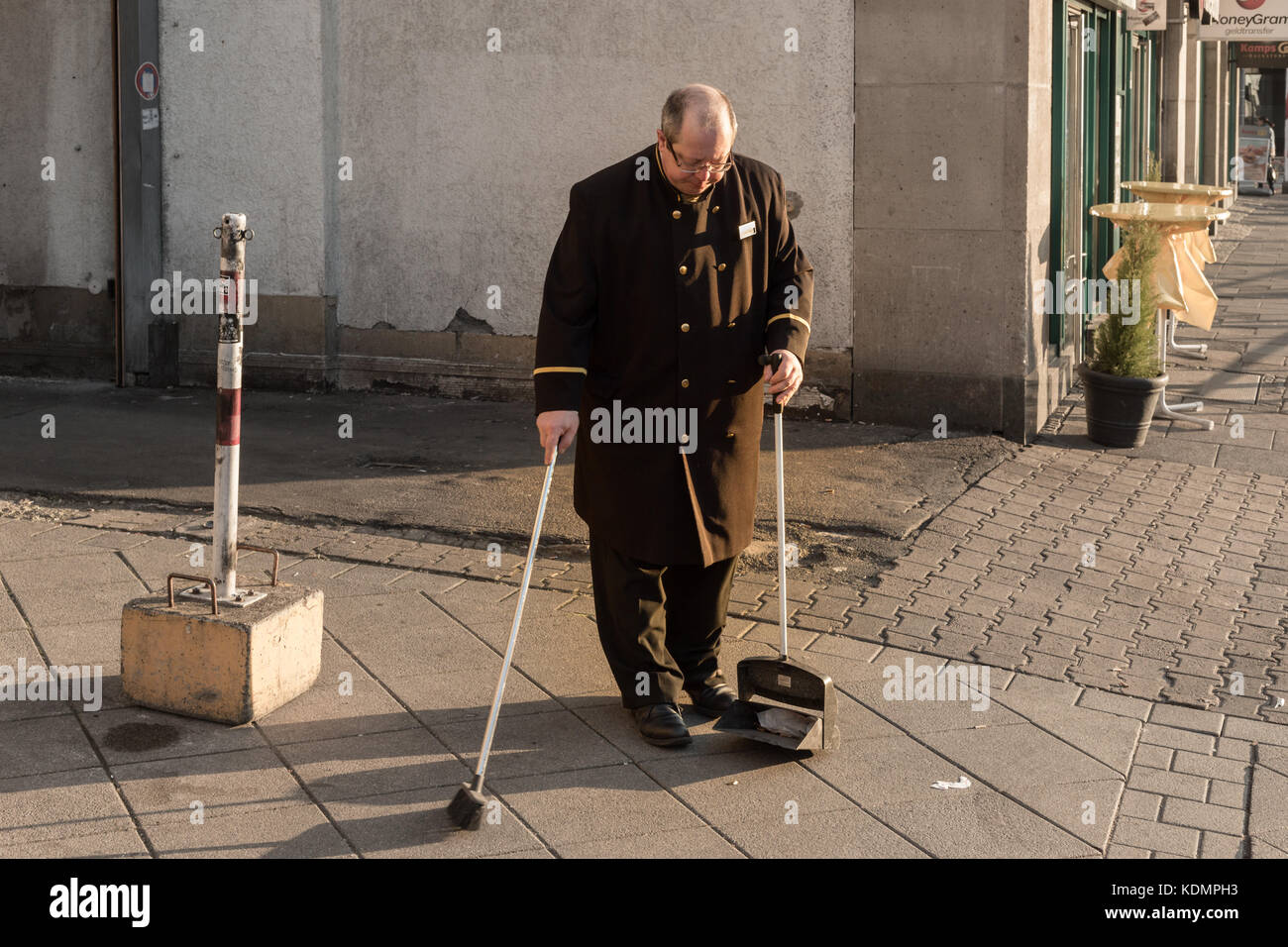 Porter sweeping ground in front of the hotel in Frankfurt, Germany ...