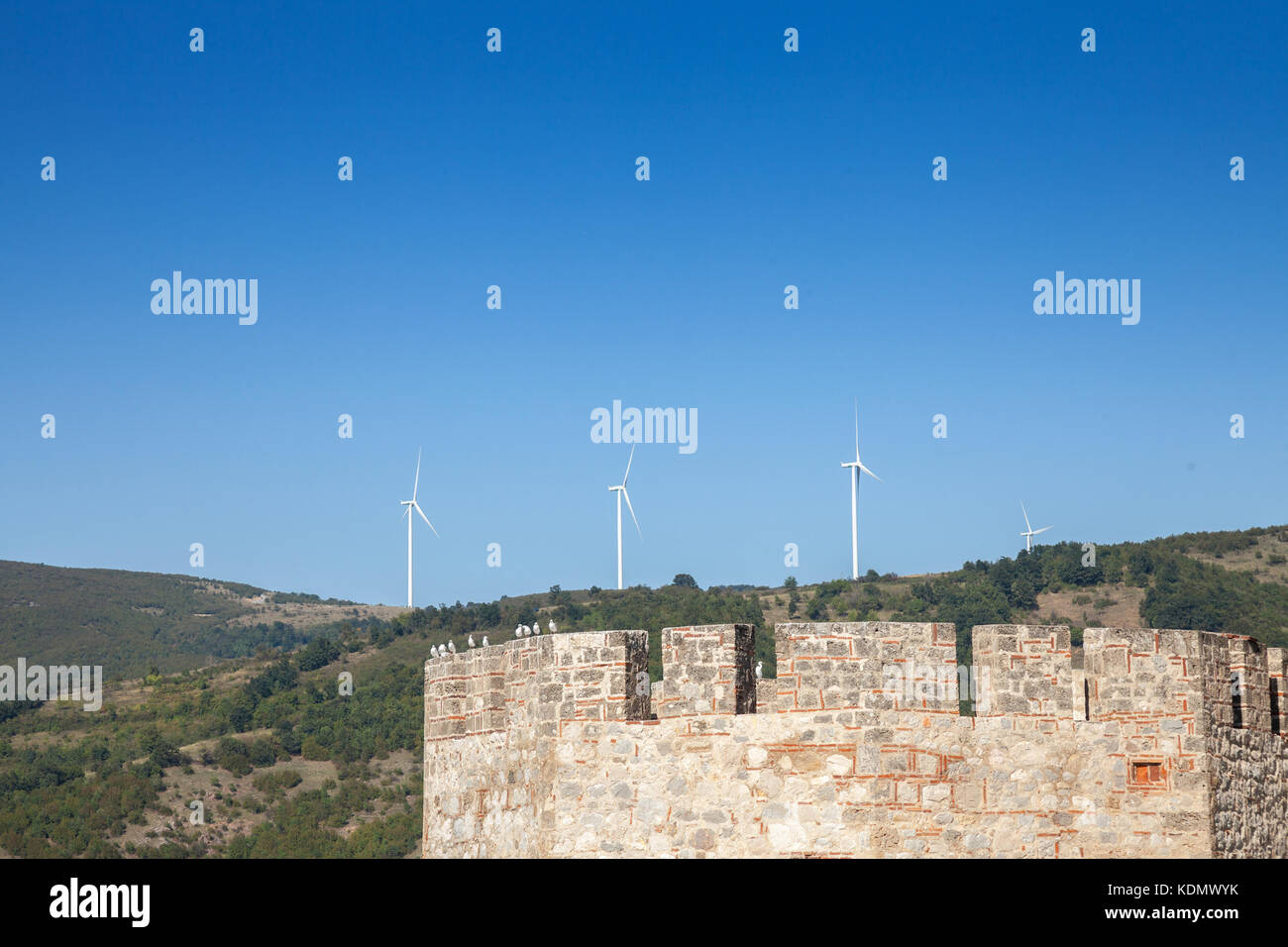 Romanian Wind Farm with Wind Turbine and windmills facing an old castle ...