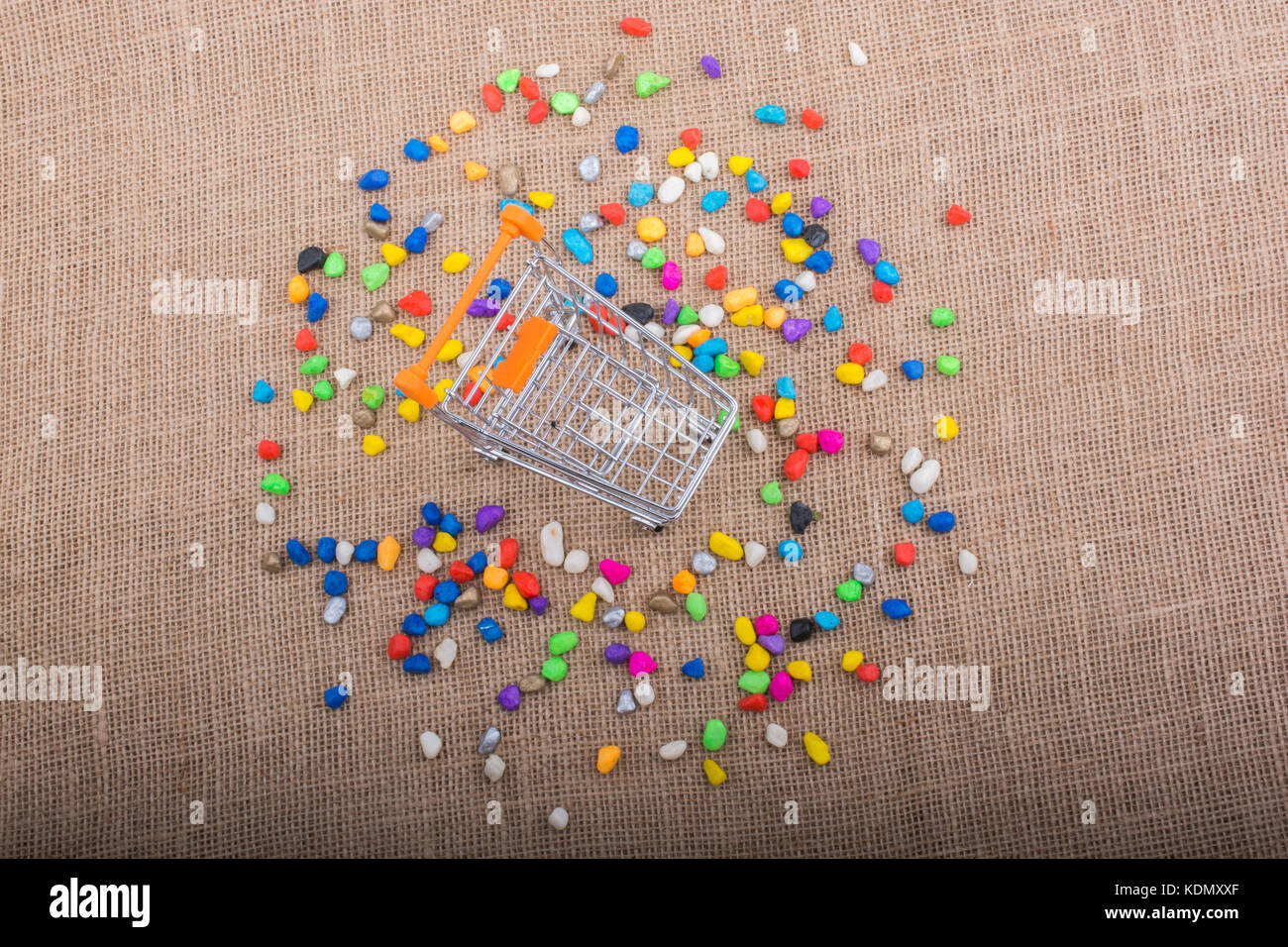 Little trolley amid Colorful pebbles on canvas background Stock Photo ...