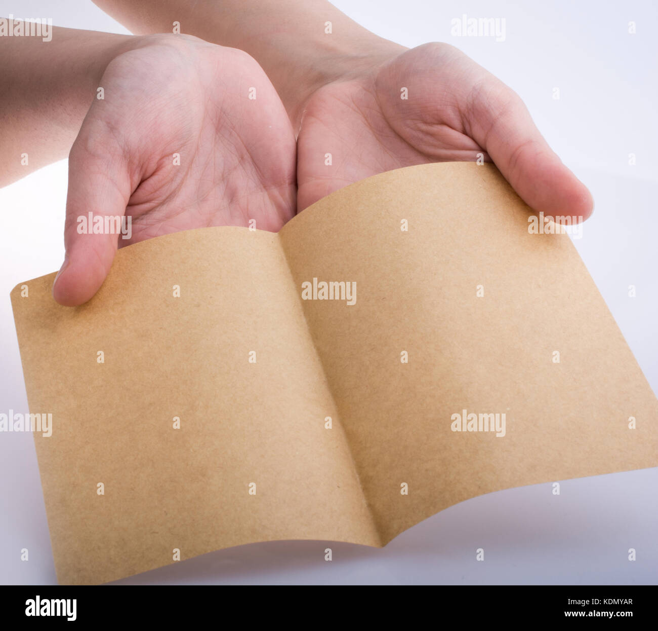Hand holding a brown color sheet of paper on a white background Stock ...