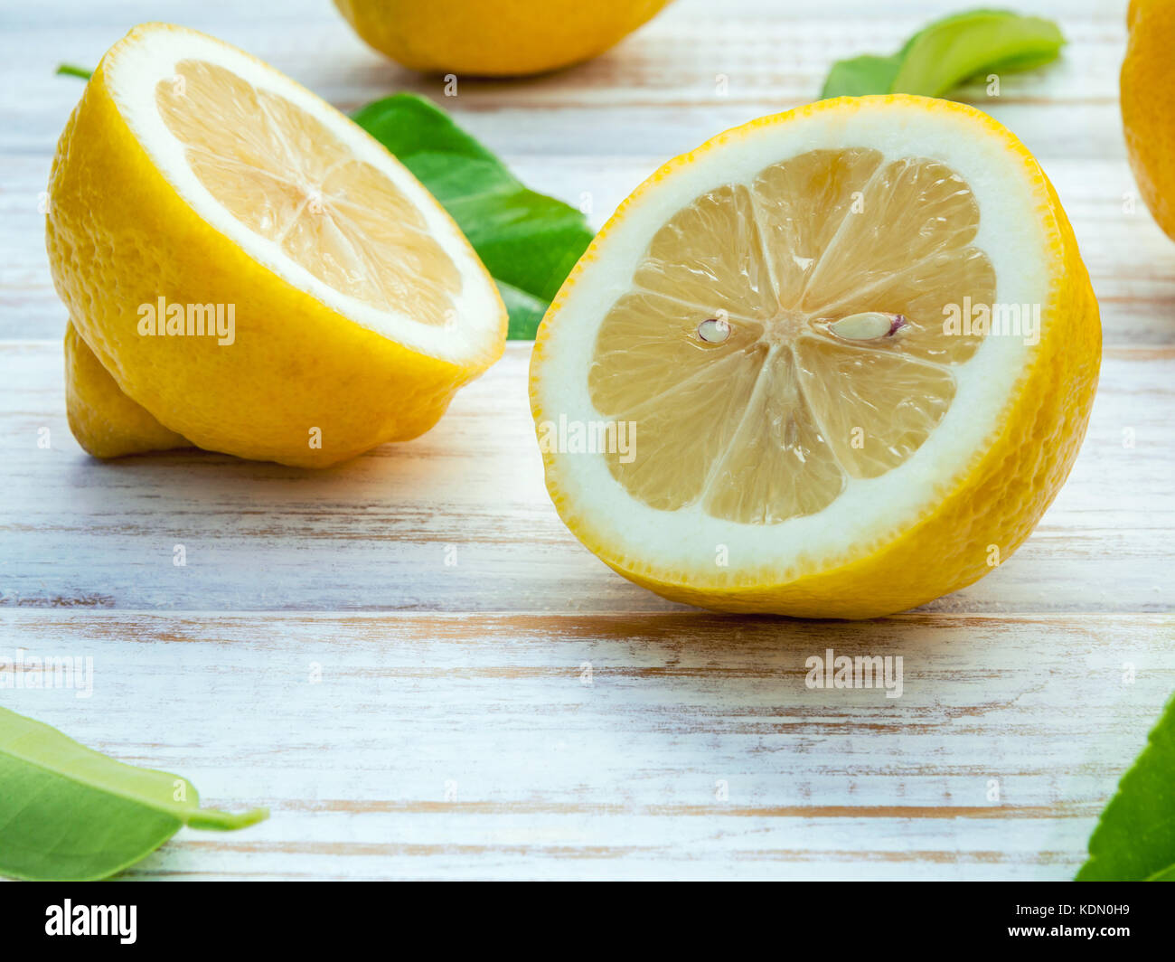 Closeup fresh lemons and lemons leaves on shabby wooden background ...
