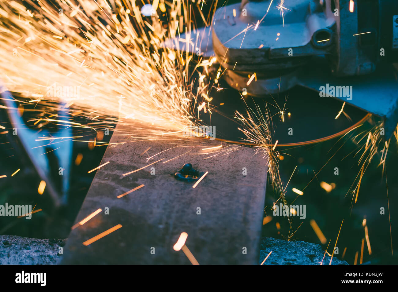 sparks flying from under the rotating disc grinder when cleaning steel ...