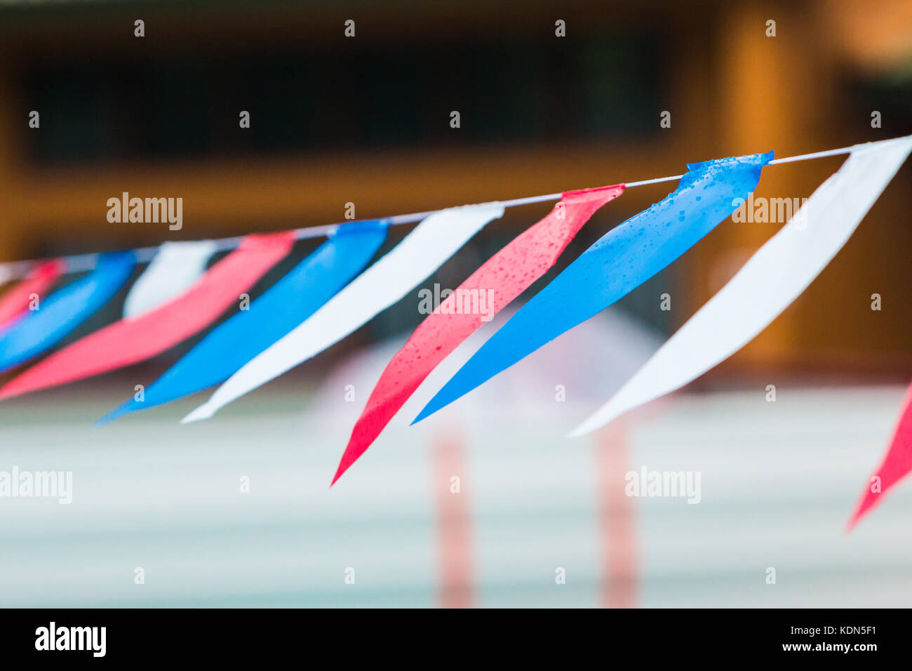 section of wet string flags in red blue and white colors, hanging ...