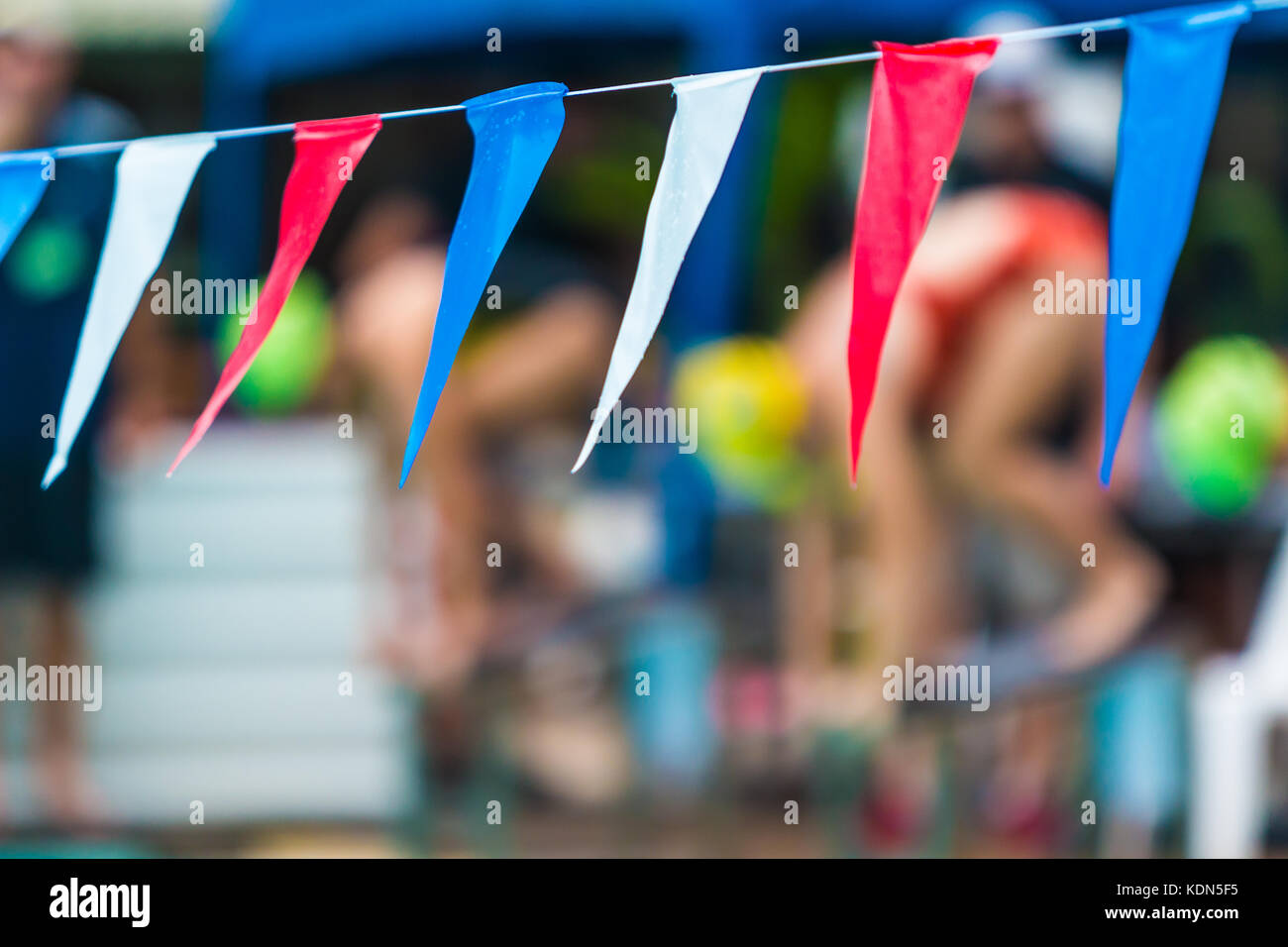 sport multi-color sling flags hanging over swimming pool, selective ...