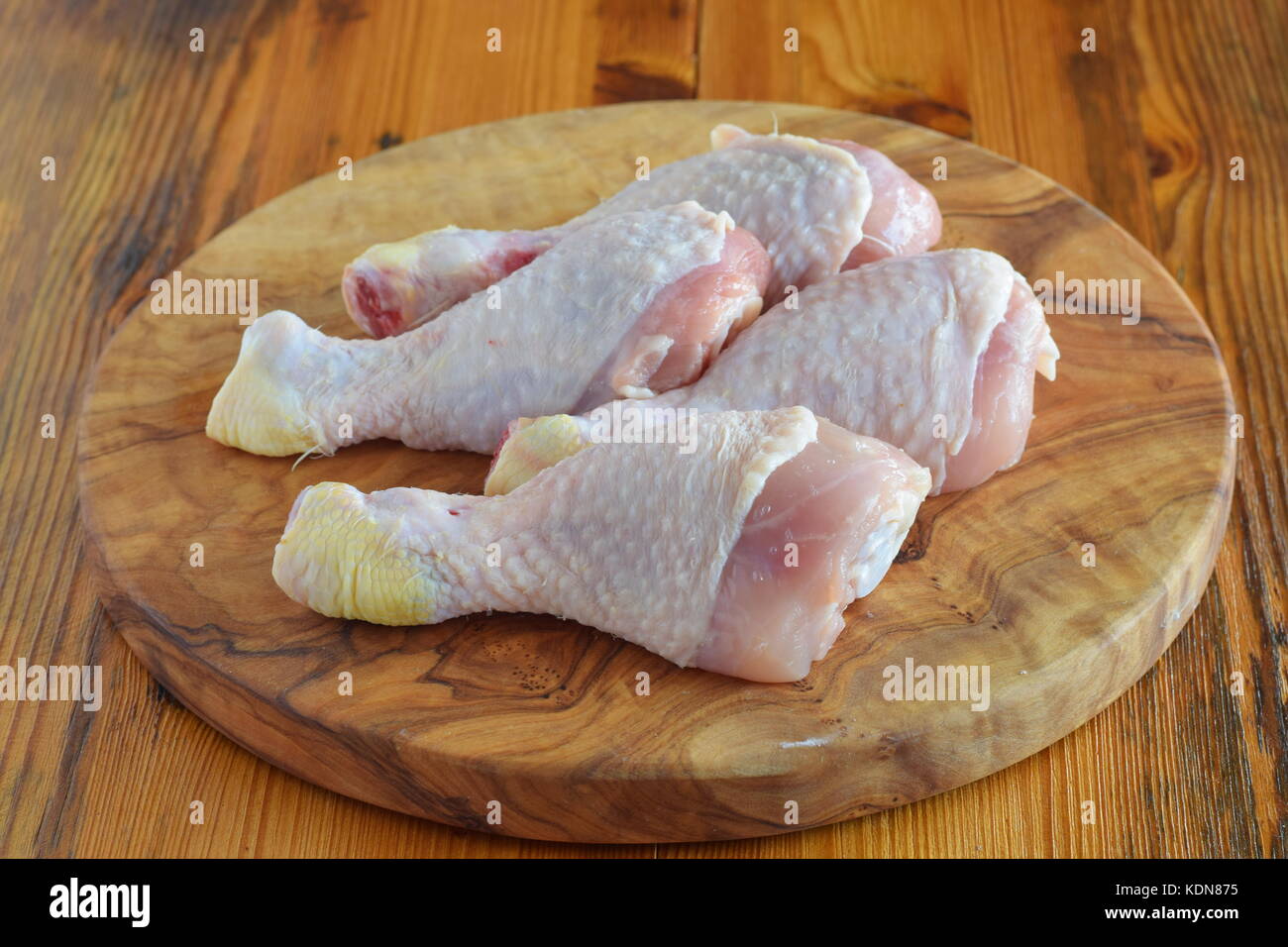 raw chicken legs on olive wooden board Stock Photo - Alamy