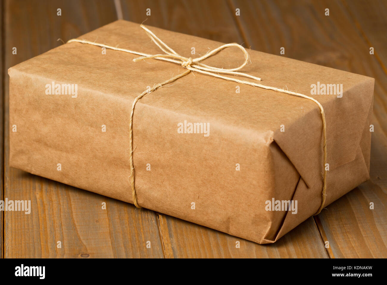 Parcel wrapped in brown paper and tied with rough twine Stock Photo - Alamy