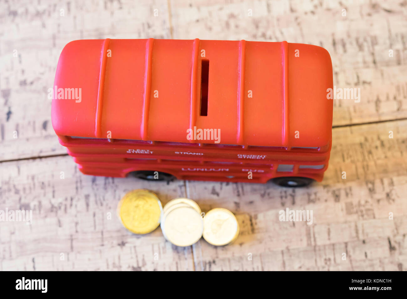 Red Bus Piggy Bank with Coins Stock Photo - Alamy