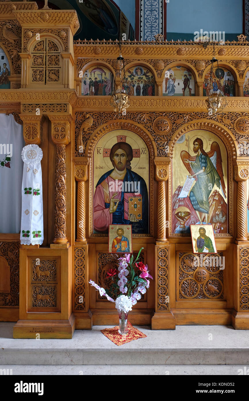 The wooden iconostasis with icons and religious paintings depicting Jesus Christ inside the ...