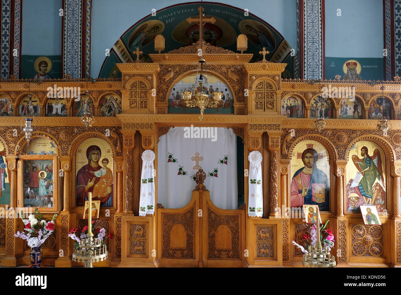 The wooden iconostasis with icons and religious paintings depicting Jesus Christ inside the ...