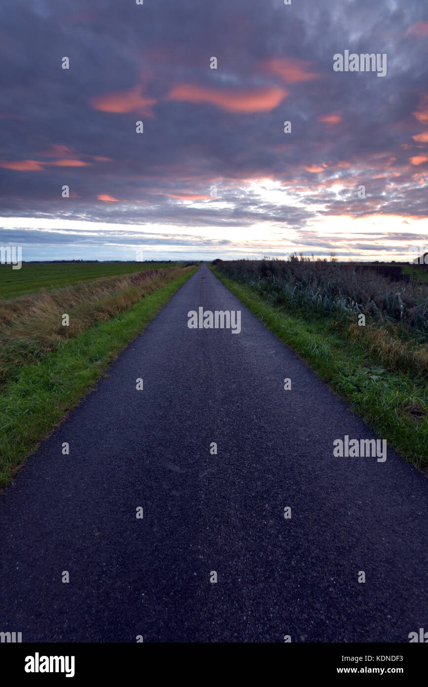 a country lane or road leading to a vanishing point on the horizon at ...