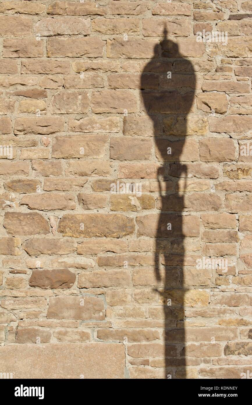 Street Lamp Post Casts a Shadow Silhouette onto an Old Stone Brick Wall ...