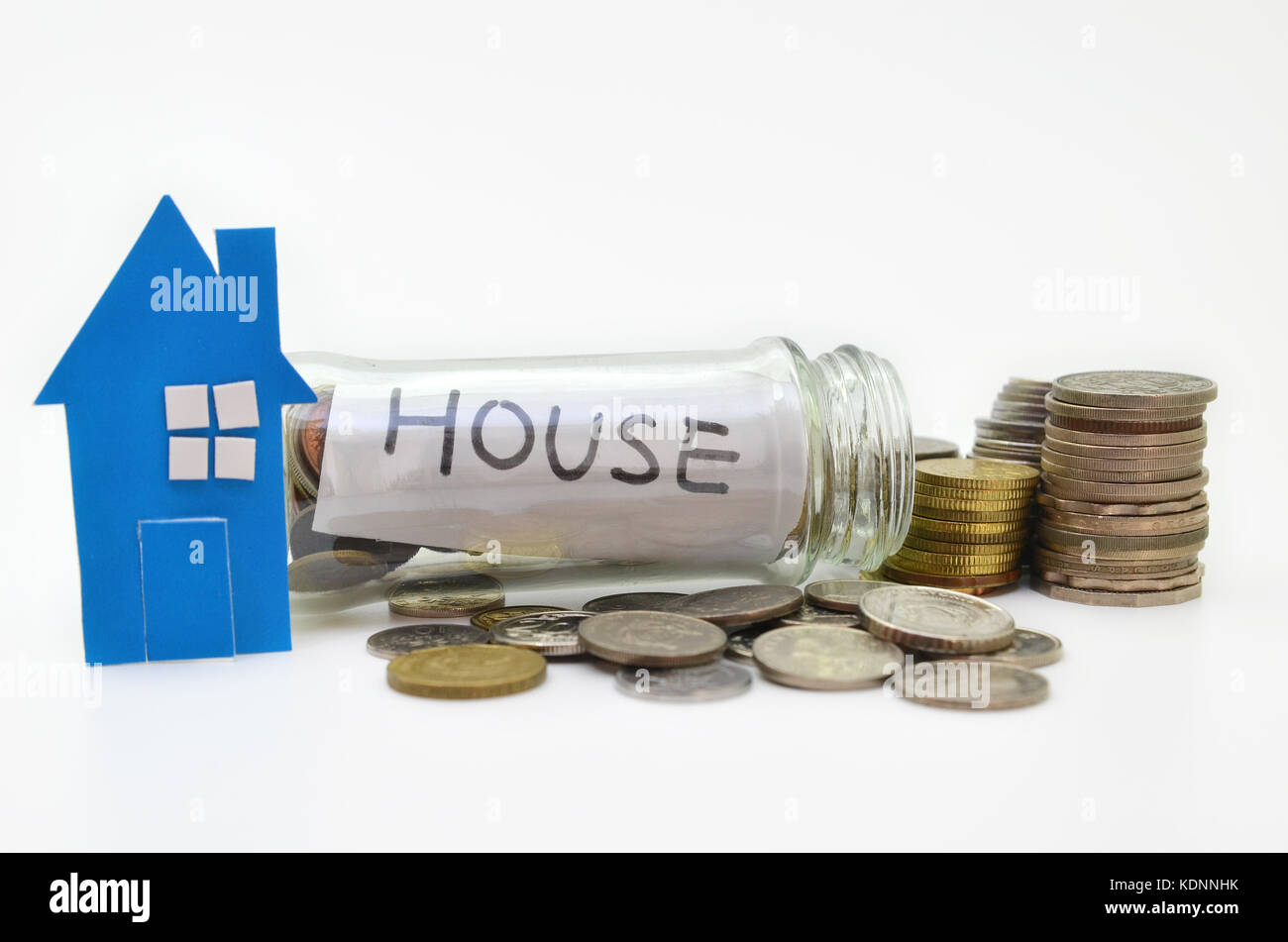 Blue paper house model and stacks of coins Stock Photo - Alamy