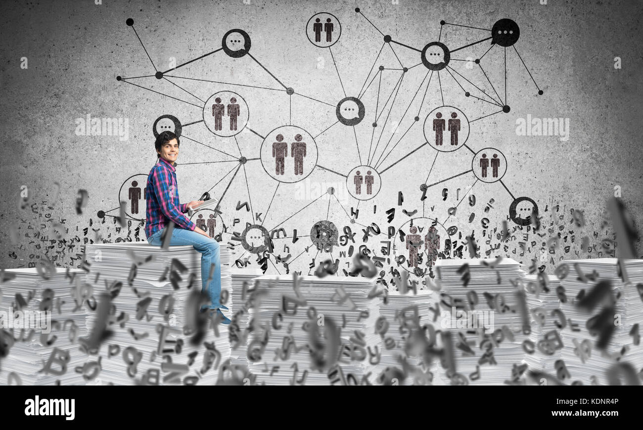Attractive man sitting on pile of paper documents Stock Photo - Alamy
