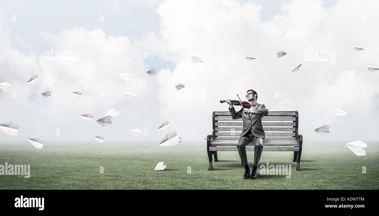 Handsome violinist in park on wooden bench play his melody Stock Photo ...