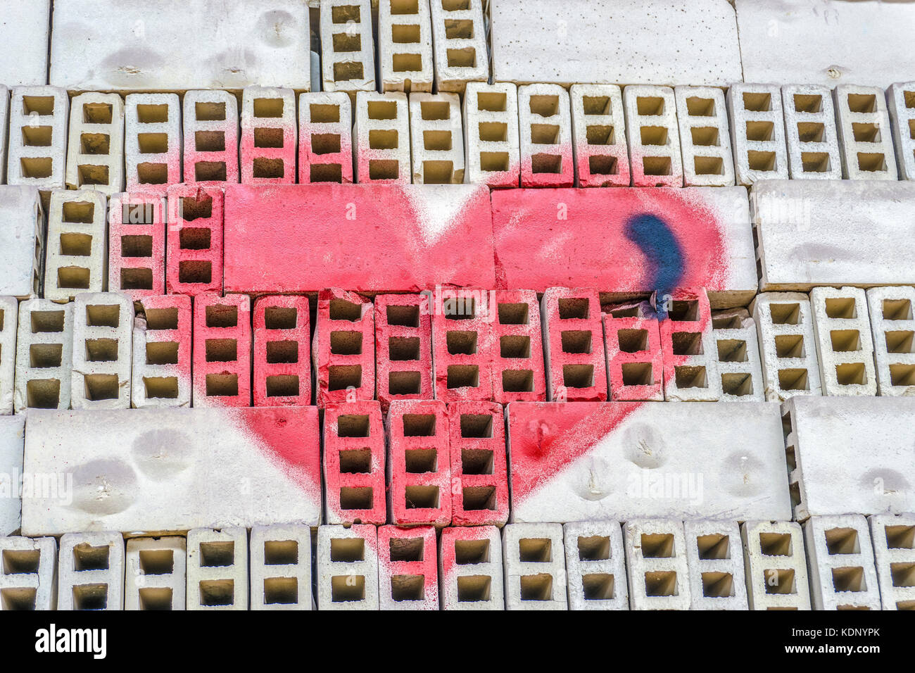 Red painted heart shape on a brick wall as background Stock Photo - Alamy