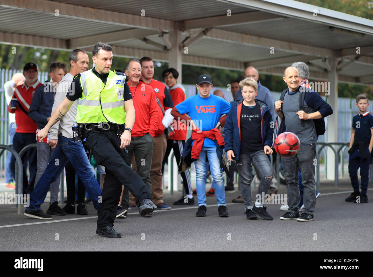 A police officer plays football with fans outside the stadium before ...