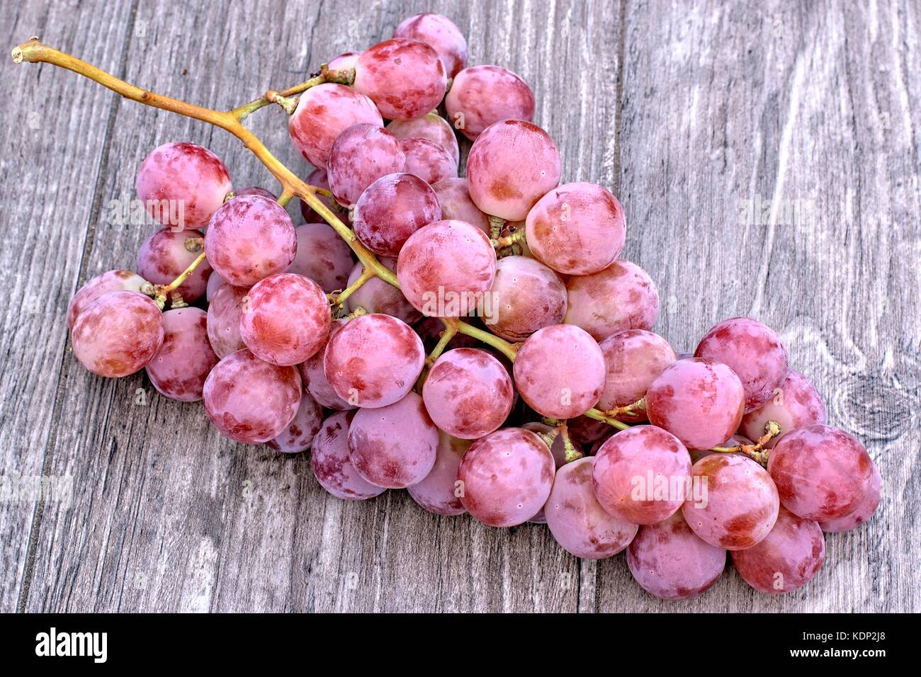 Fresh ripe red grapes on a wooden background Stock Photo - Alamy