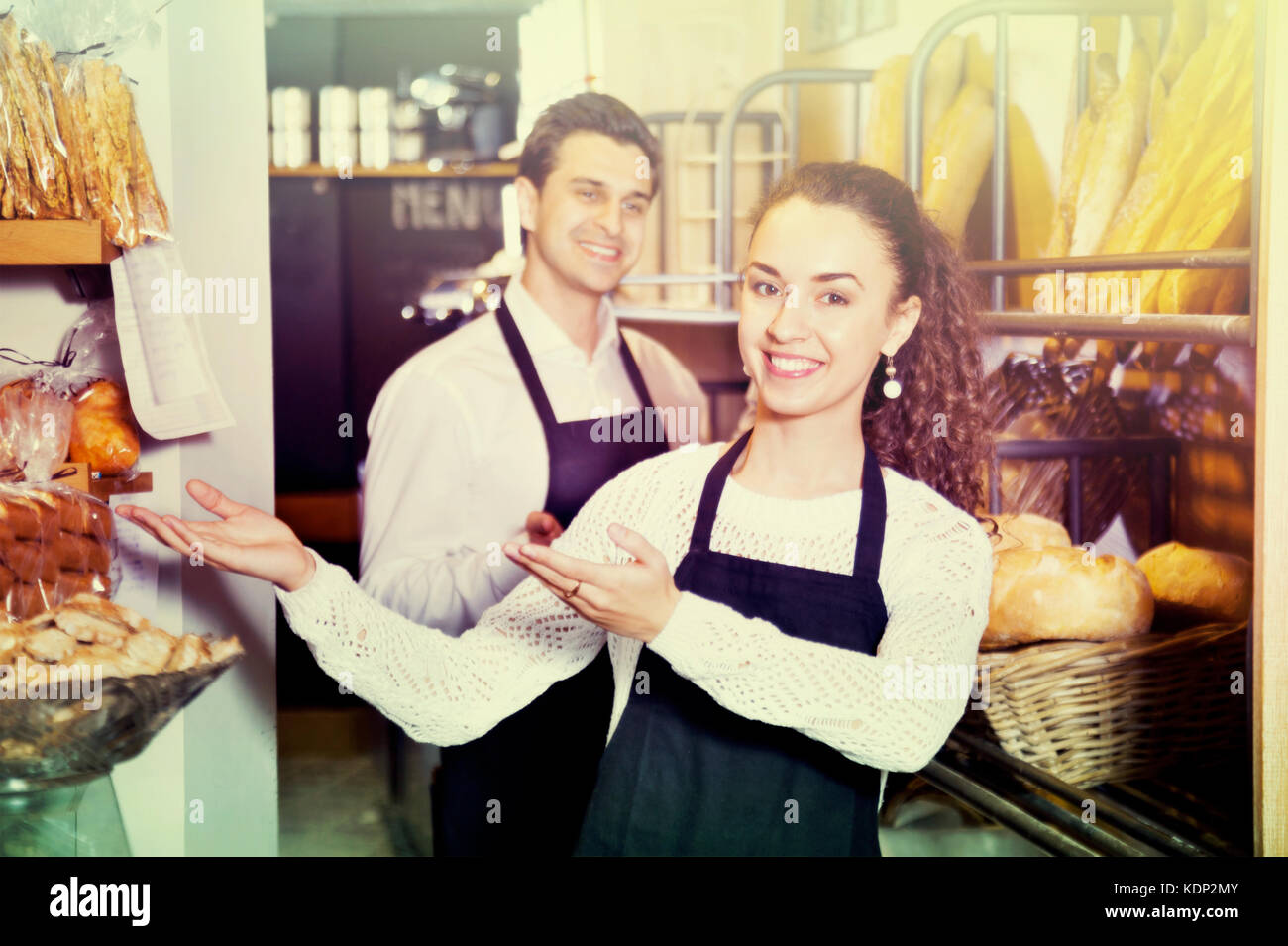 Portrait of charming smiling couple at bakery display with pastry Stock ...