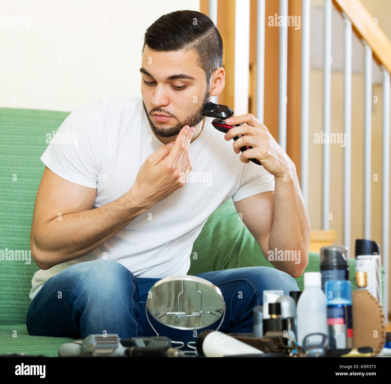 Beautiful young guy shaving by electric shaver at home Stock Photo - Alamy