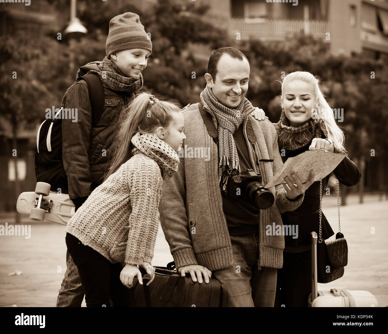 Happy middle class family of four checking the direction in a map Stock ...