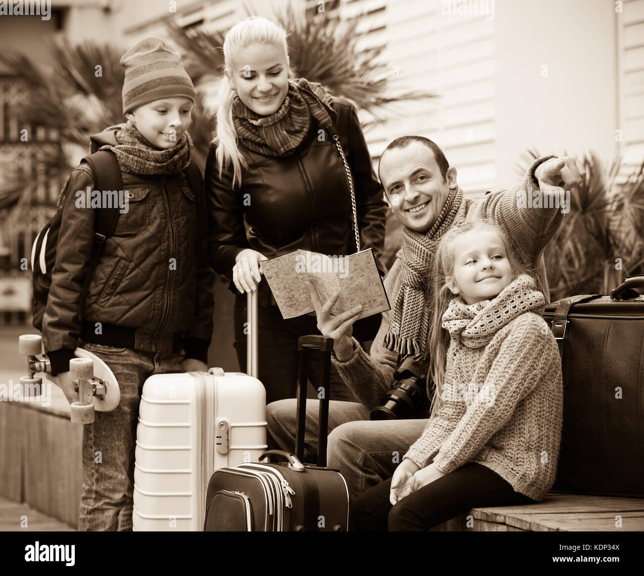 Happy middle class family of four checking direction in a city map ...