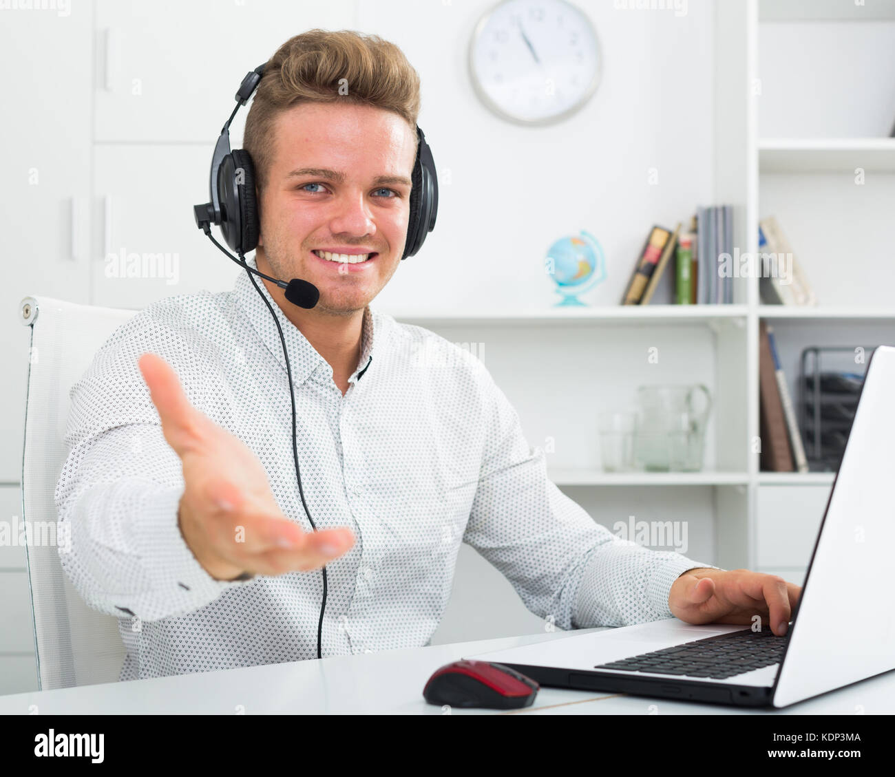 Young professional inviting to join him in call center Stock Photo - Alamy