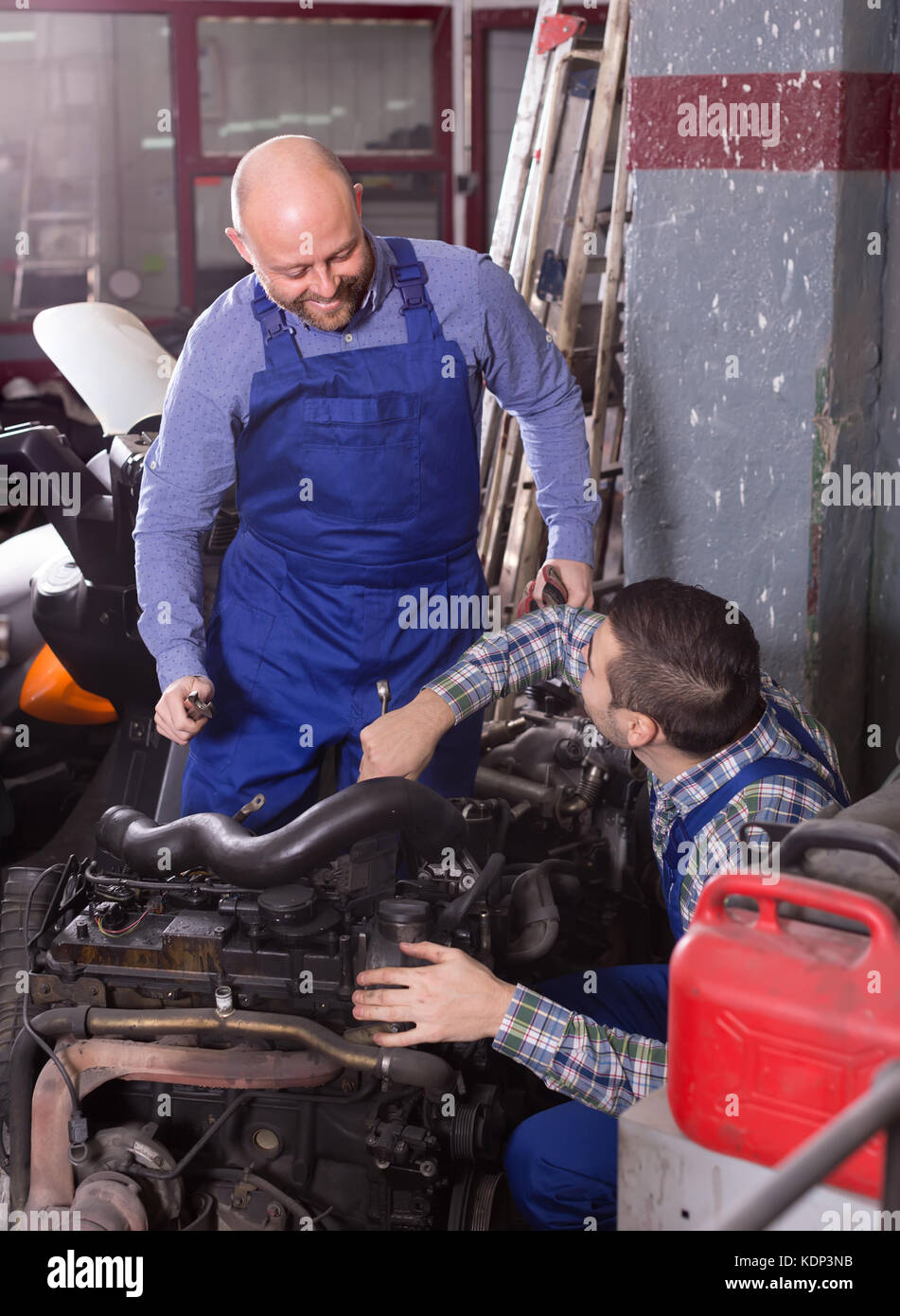 Portrait of two smiling professional car mechanics at workshop Stock ...