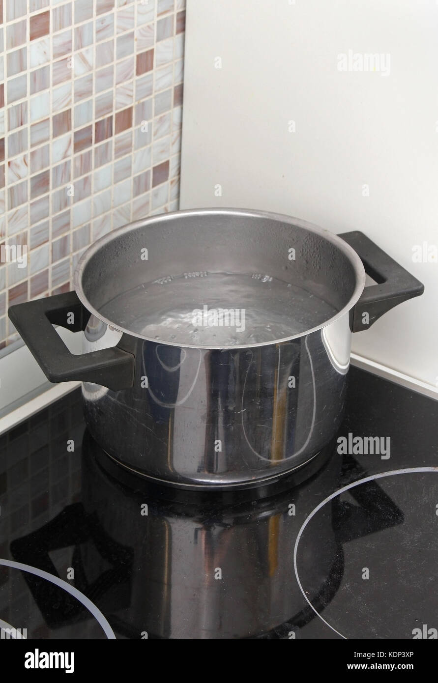 Water boiling in silver pot on modern kitchen stove Stock Photo - Alamy