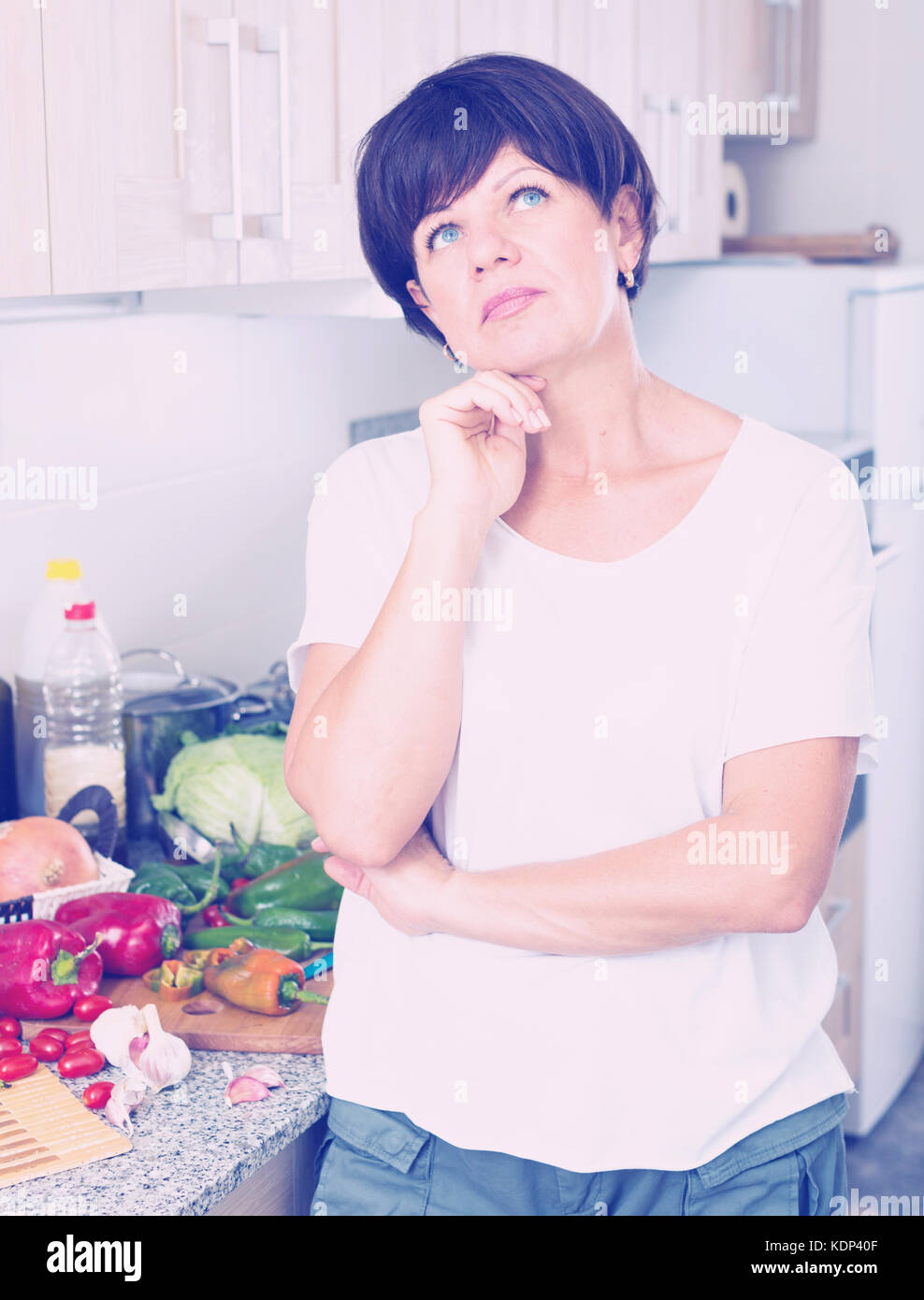 Portrait of disappointed senior woman housewife standing at kitchen ...