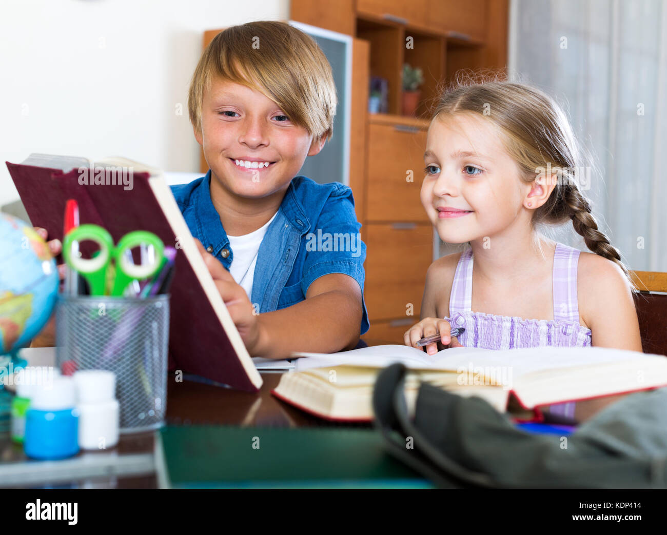 Happy big brother helping little sister to do homework at home Stock ...