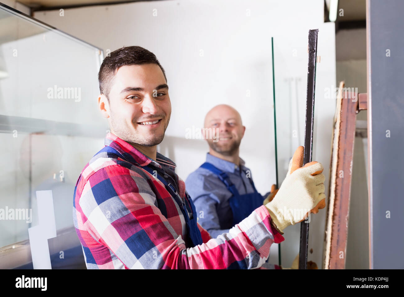 Happy workers working with glass for windows at workshop Stock Photo ...