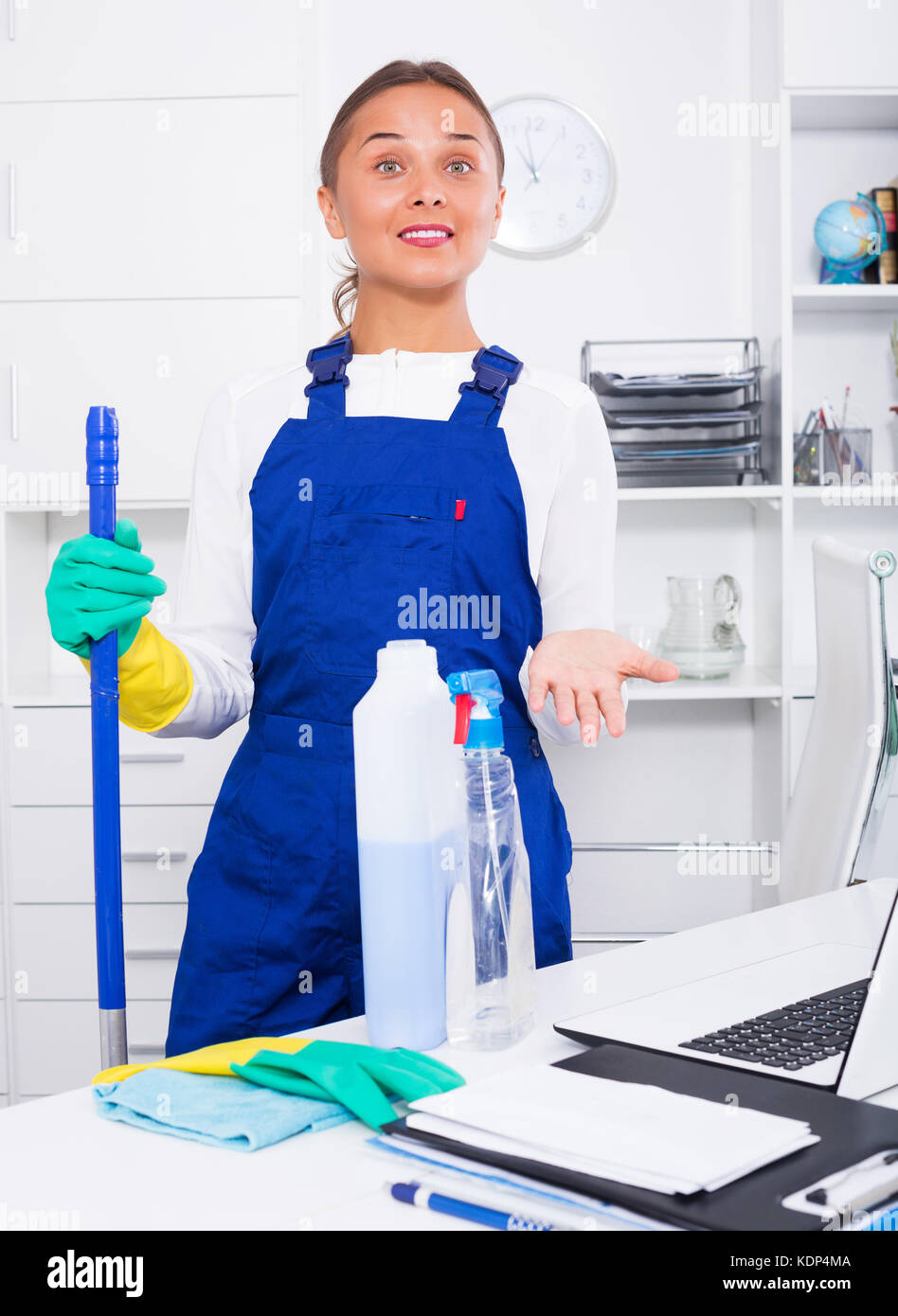 Positive brunette woman wearing uniform cleaning at company office ...
