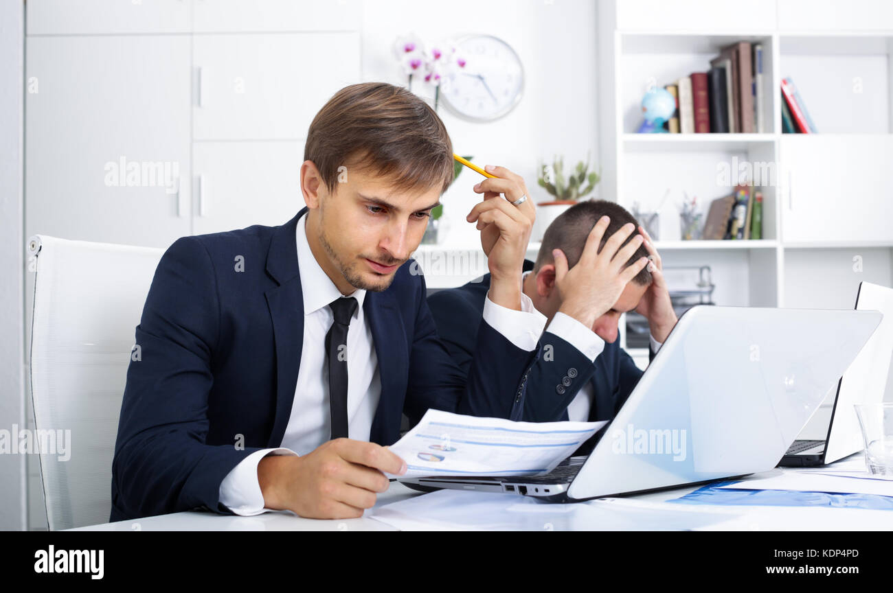 Two sad young men coworkers experiencing business failure in firm ...