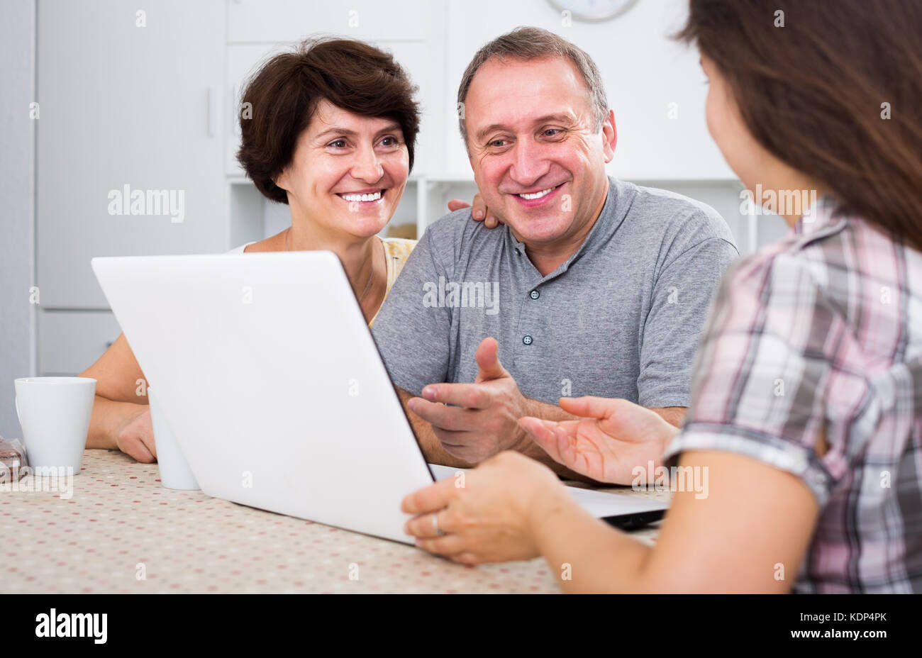 Positive daughter learning her elderly parents searching documents on ...