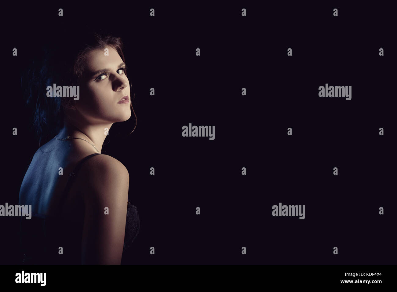 beautiful sad young woman on black background with copy space looking ...