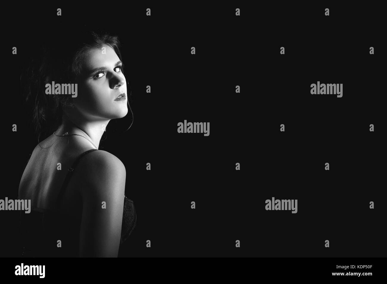 beautiful sad young woman on black background with copy space looking ...