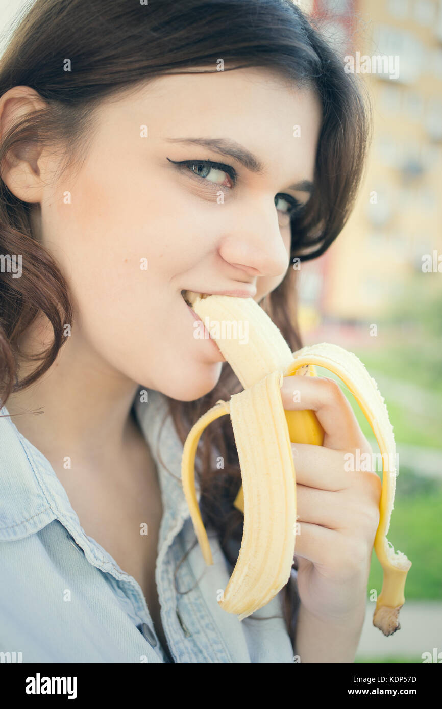 sensual happy young woman eats banana looking at camera Stock Photo - Alamy