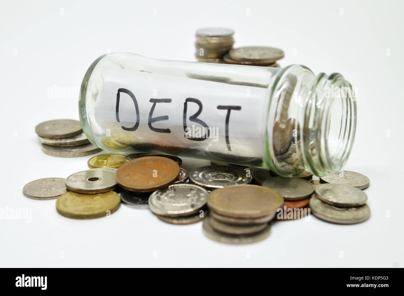 Debt lable in a glass jar with coins spilling out isolated on white ...
