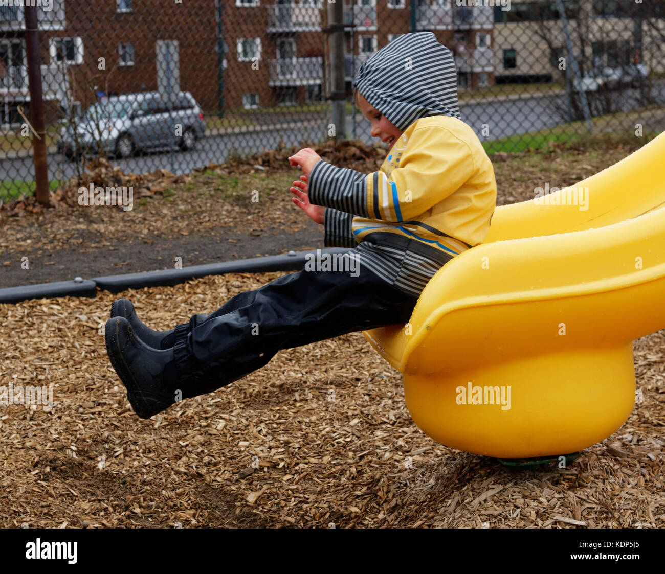 A little boy (5 yrs old) sliding off a slide in a park Stock Photo - Alamy
