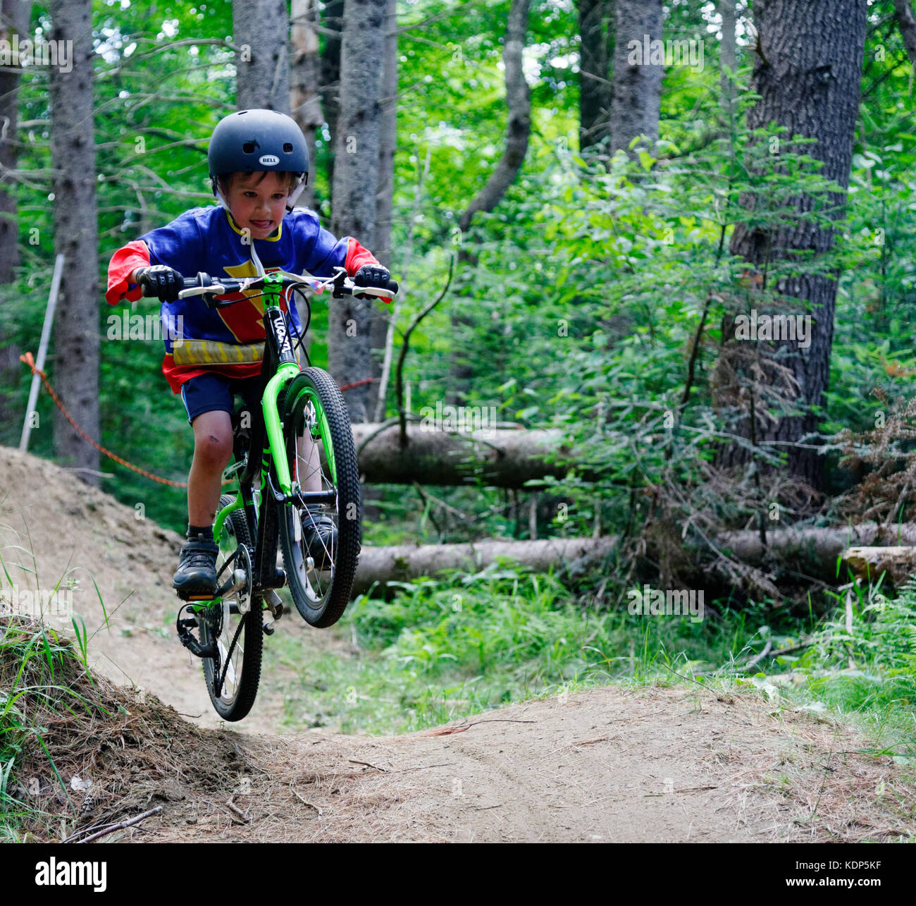 A young boy (5 yrs old) jumping in a mountain bike Stock Photo - Alamy