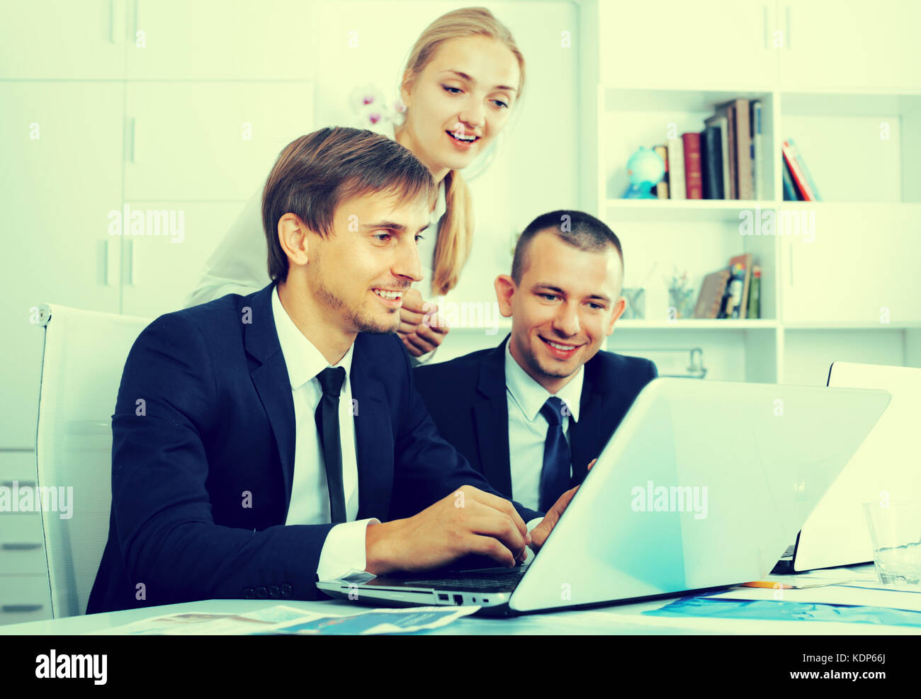 three glad business male and female assistants wearing formalwear ...