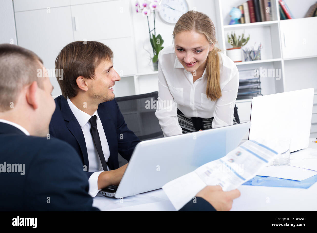 Happy business male and female assistants in formalwear holding paper ...