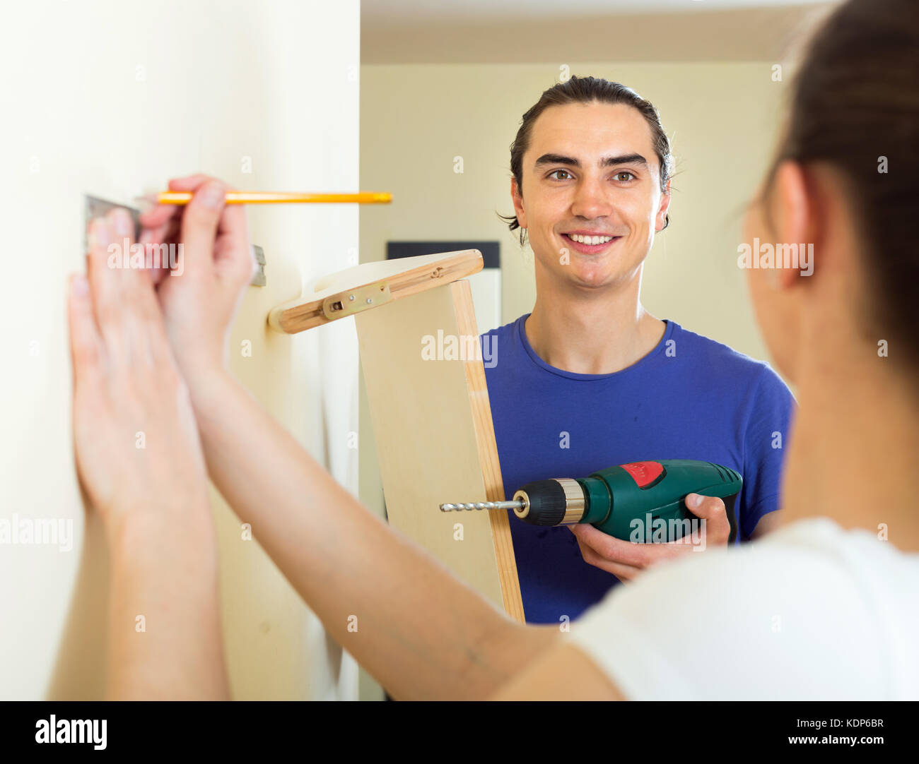 Family doing improvement at home and smiling Stock Photo - Alamy