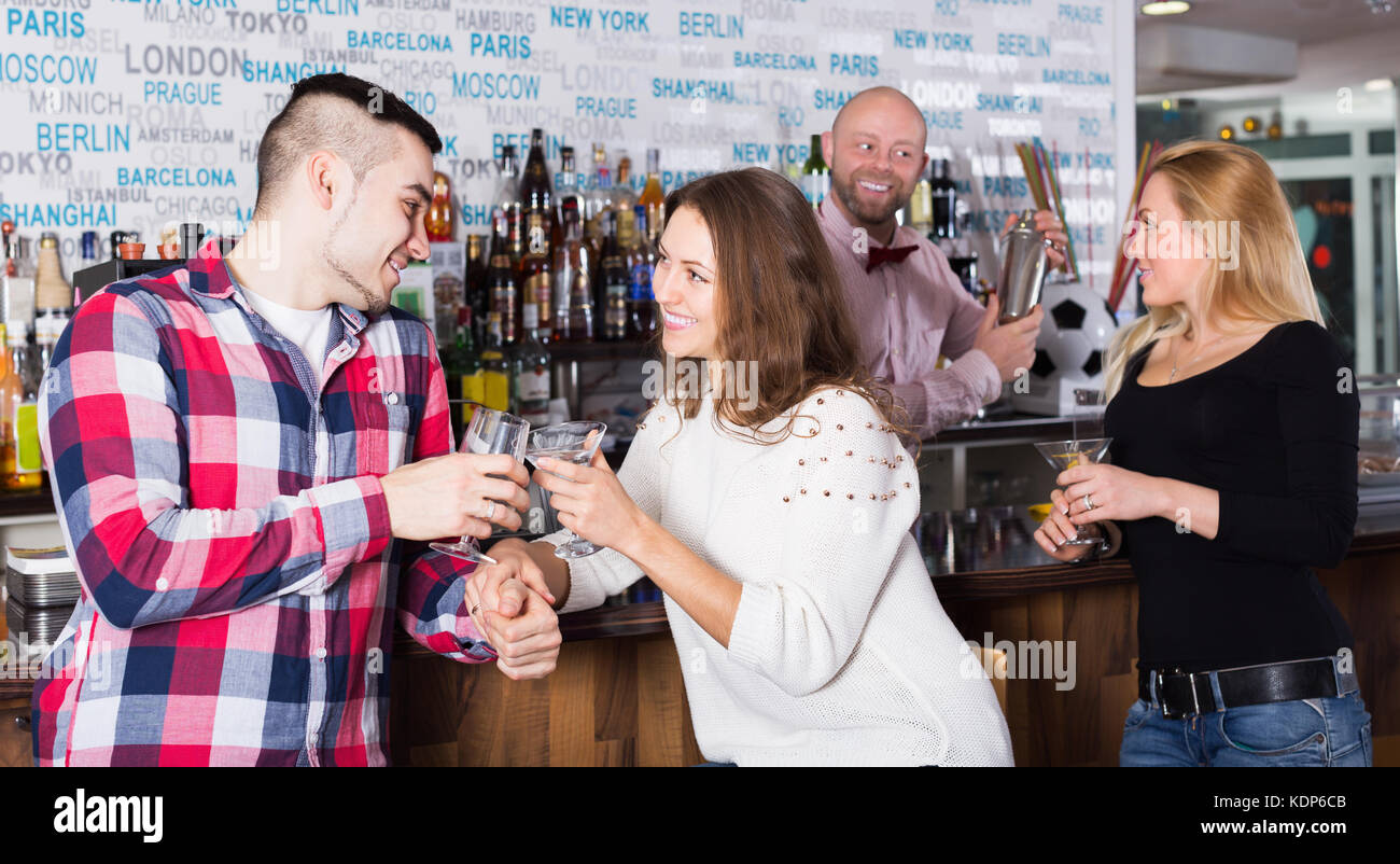Smiling friends drinking and chatting with barman at bar counter Stock ...