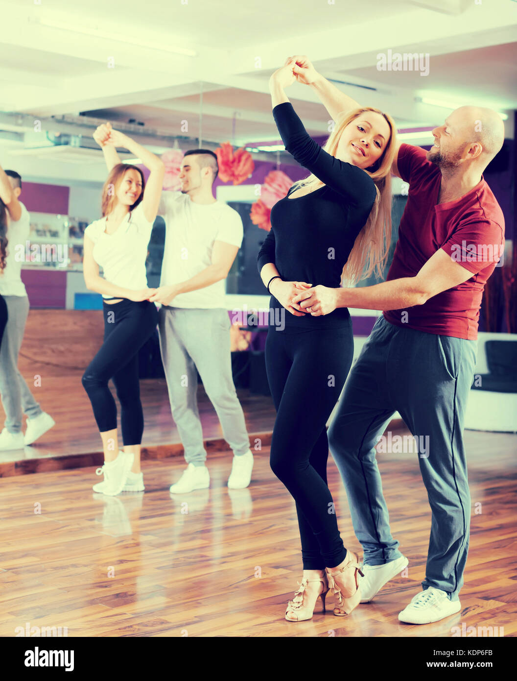 Two smiling young couples having dancing class in club Stock Photo - Alamy