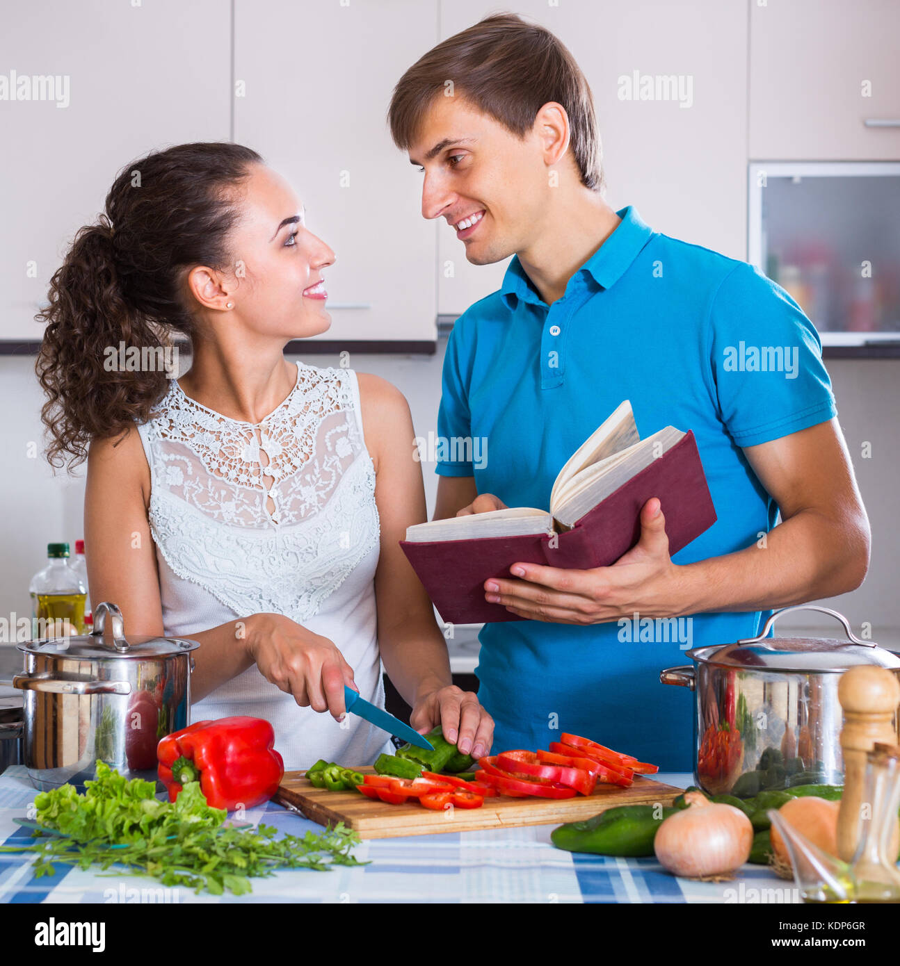 Young family couple cooking vegetables in domestic kitchen Stock Photo ...