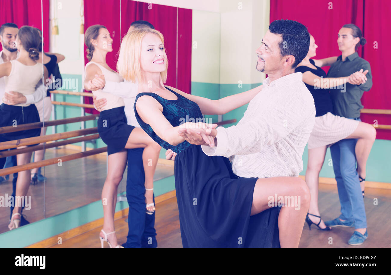 Smiling spanish men and women enjoying of tango in class Stock Photo ...
